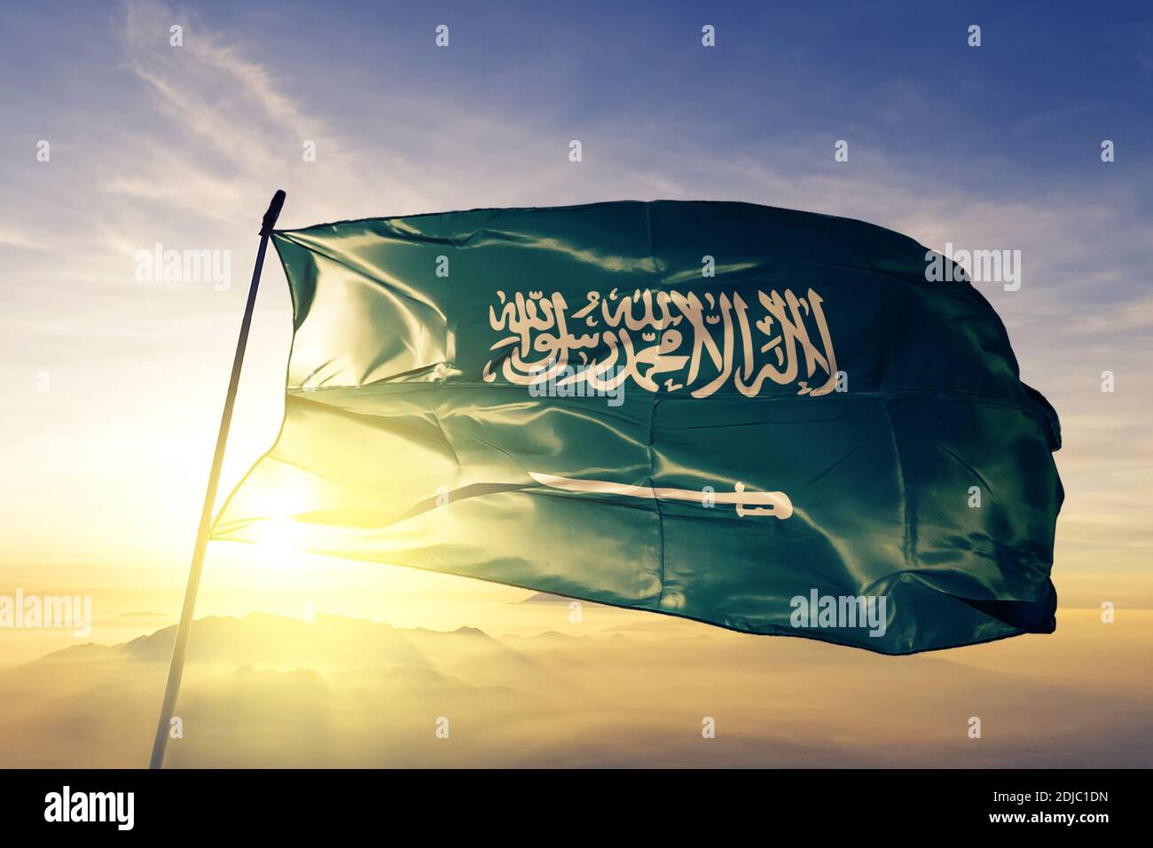 Saudi Arabia flag waving on the top sunrise mist fog Stock Photo - Alamy