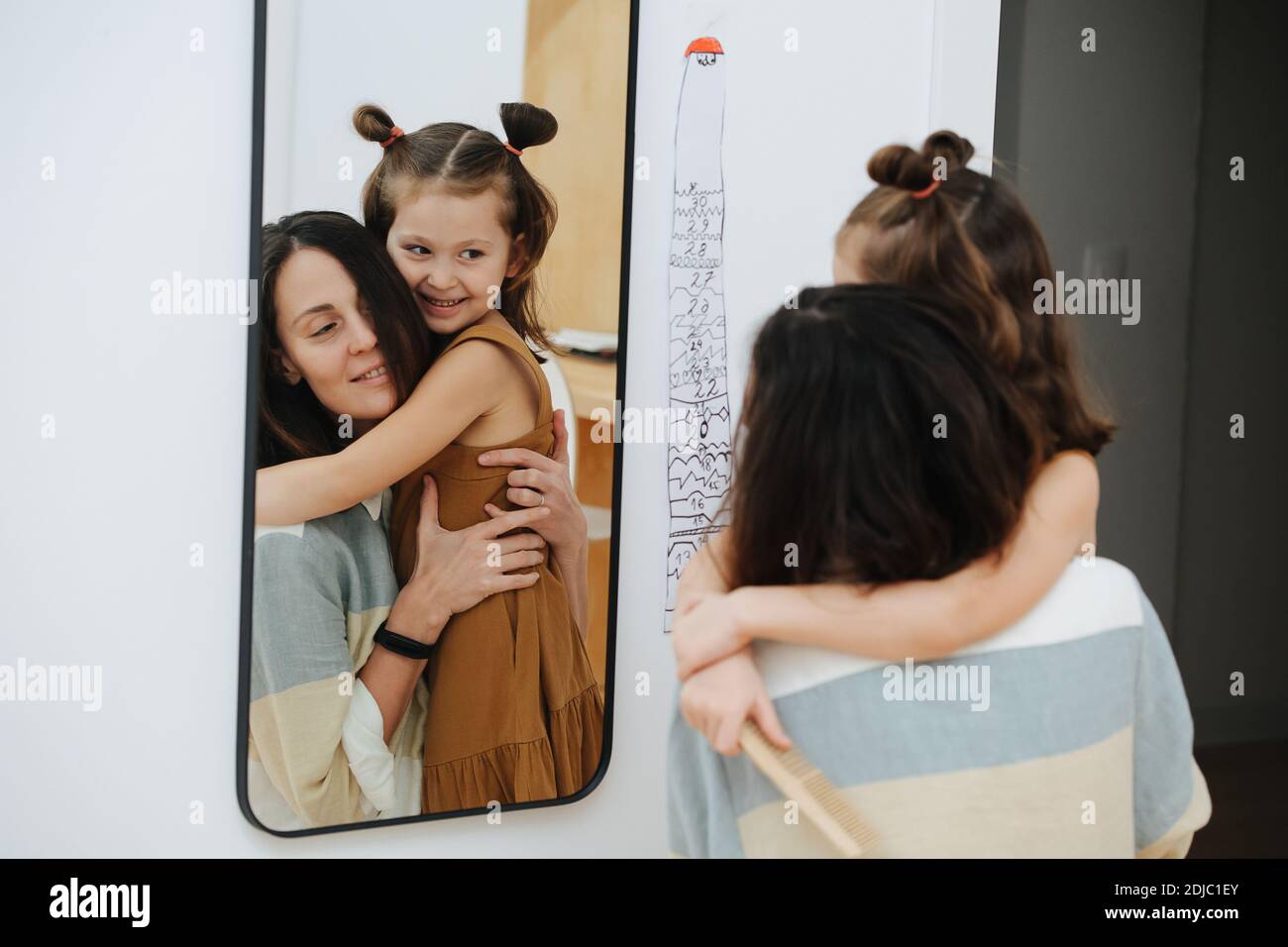 Mom and daughter are cute looking in the mirror Stock Photo - Alamy