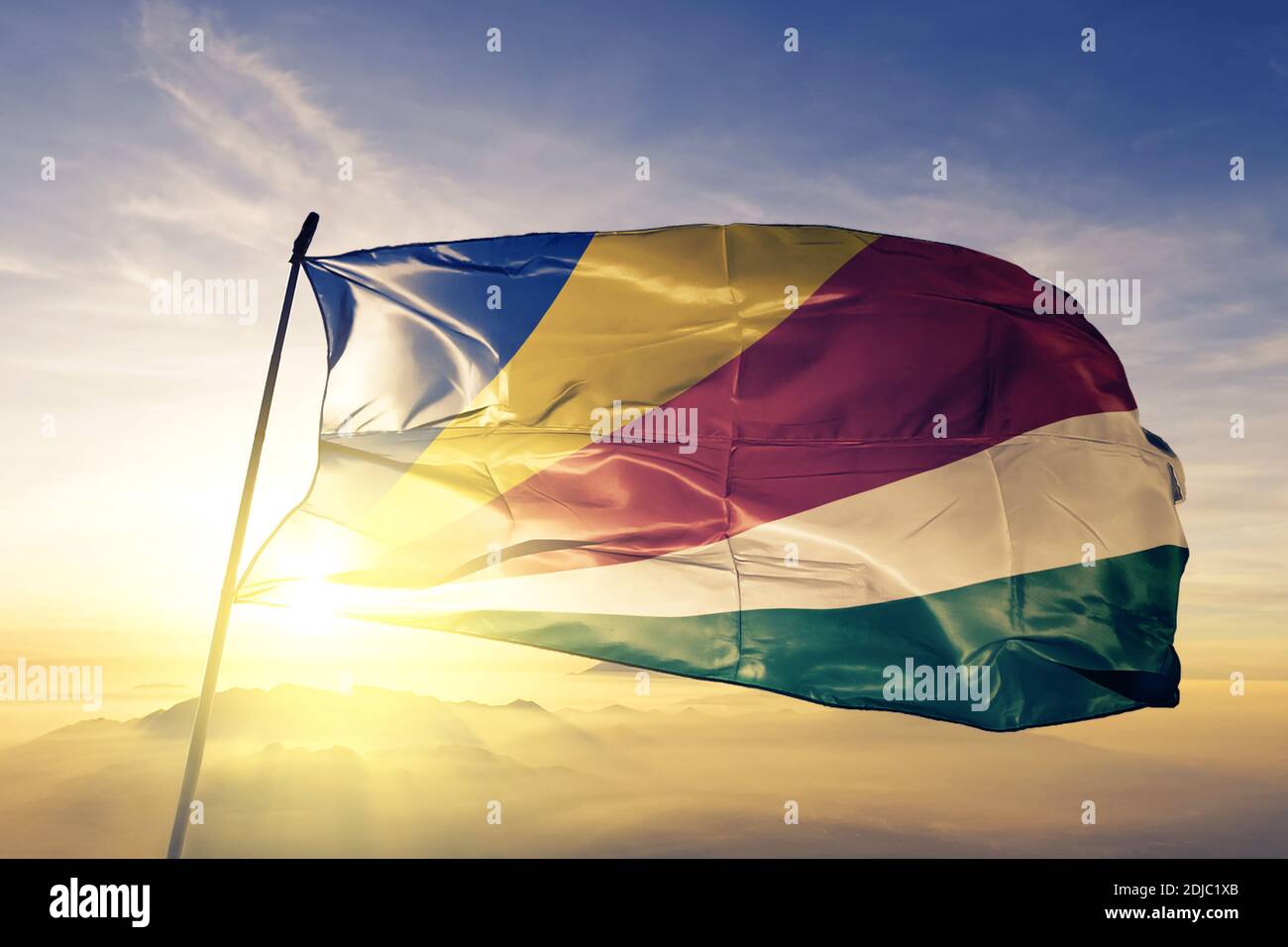 Seychelles flag waving on the top sunrise mist fog Stock Photo - Alamy