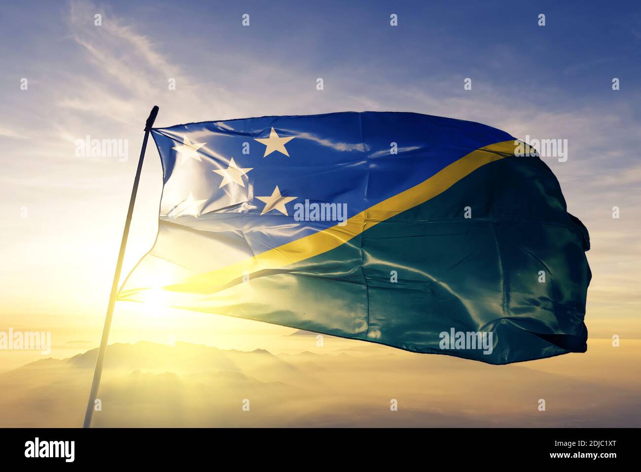 Solomon Islands flag waving on the top sunrise mist fog Stock Photo - Alamy
