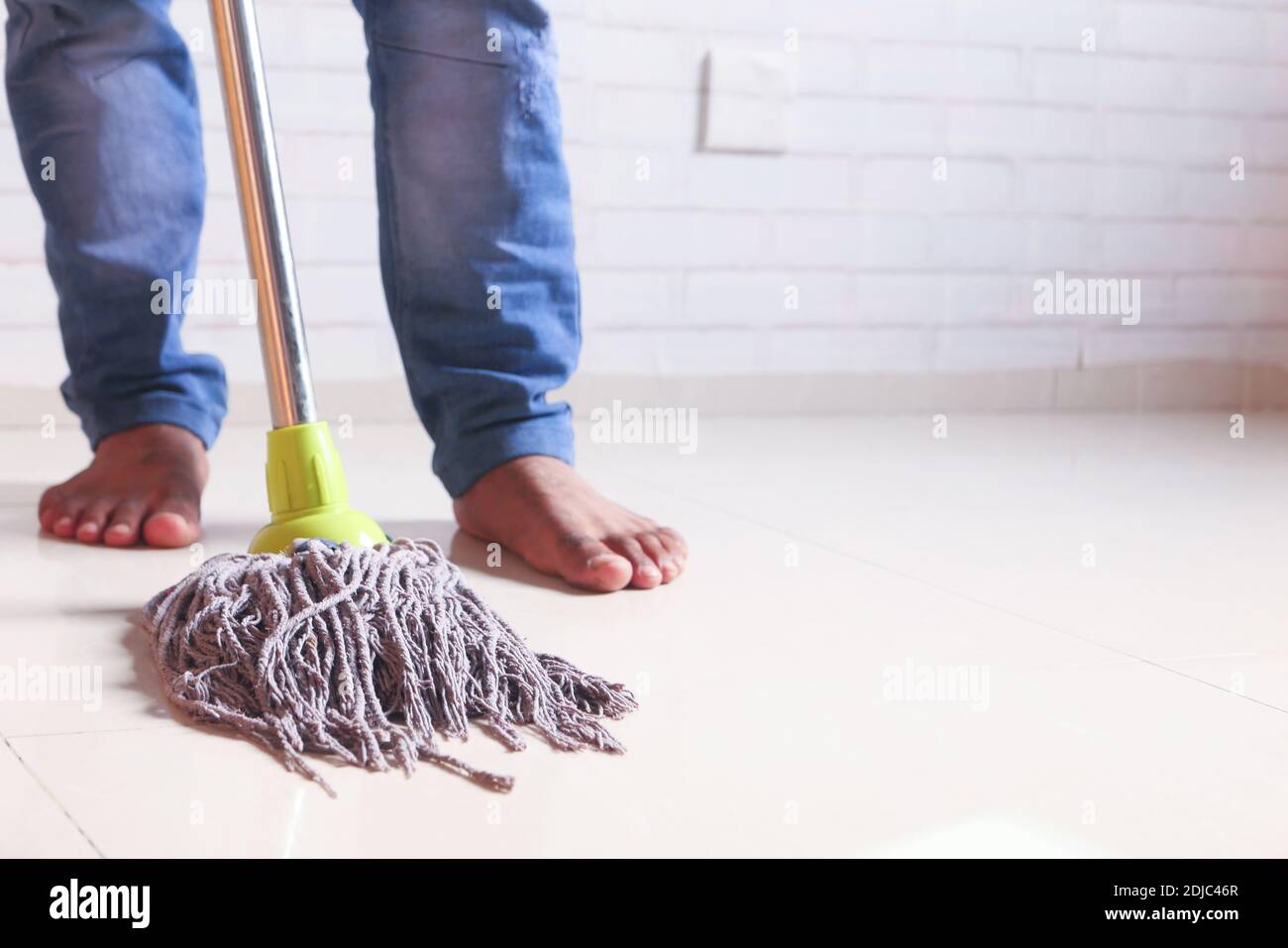 cleaning tiles floor with mop Stock Photo - Alamy