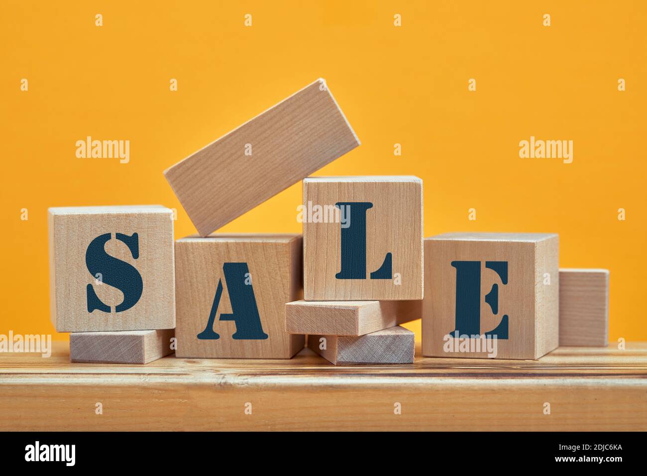 wooden blocks with the wordings SALE, isolated against yellow ...