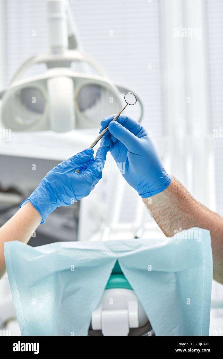 Close-up of the hands of a dentist and nurse surgeon over an operating ...