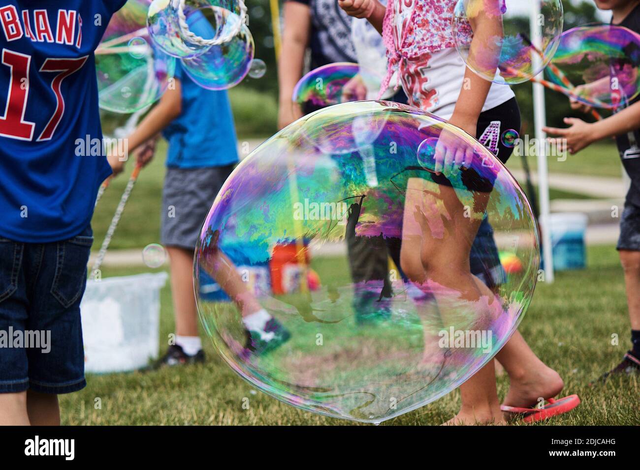 Children Playing With Bubbles In Park Stock Photo - Alamy