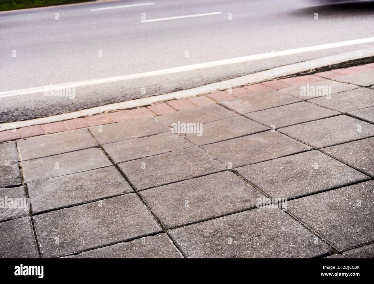 The road side pathway is paved with square blocks of concrete Stock ...