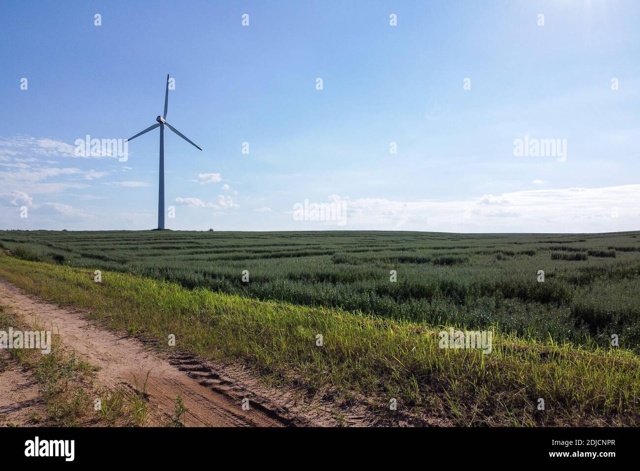 Wind turbine, rural road and summer agricultural field. Wind power ...
