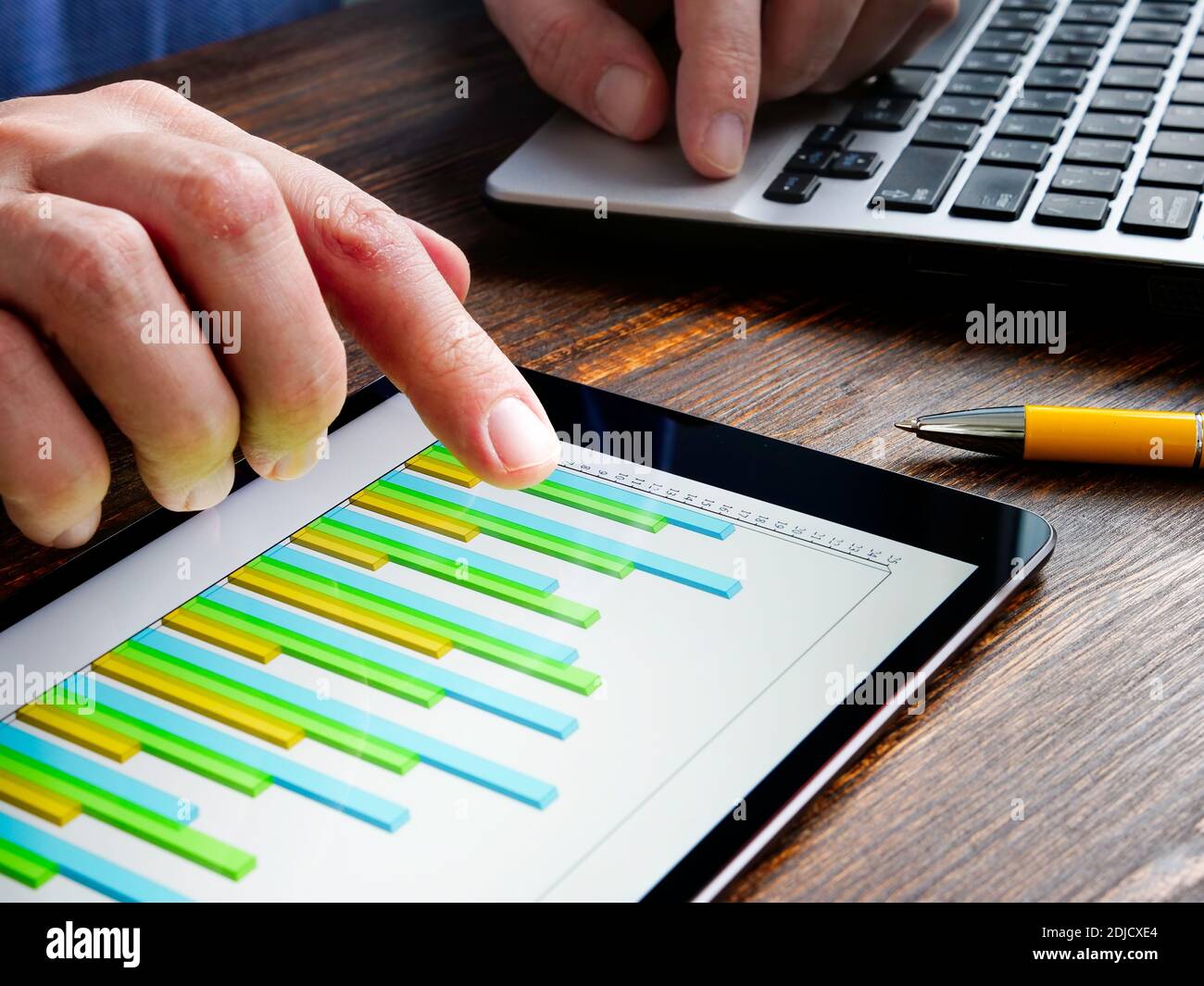 Man checks a business graph on a tablet. Modern paperless office work ...