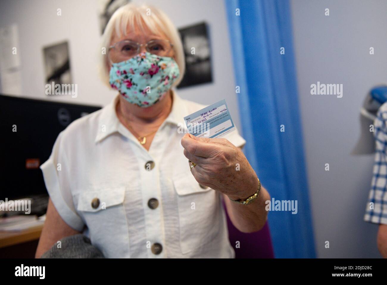Maureen Hughes, 84, holds her vaccination record card after receiving ...