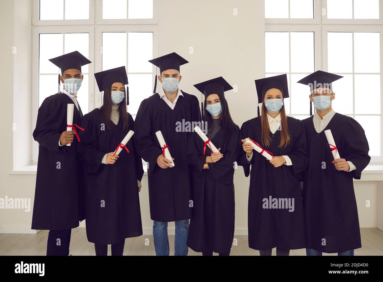 Group of diverse university or college graduates in face masks holding ...