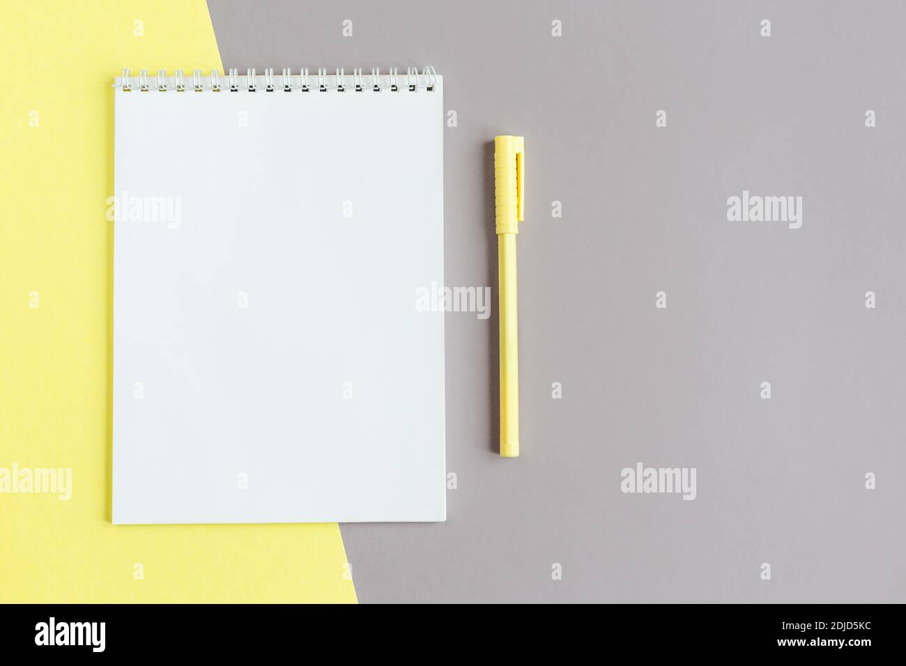 Notebook with blank page and pen on a grey and yellow background. Flat ...