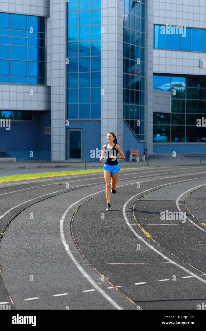 Athlete runner running on athletic track training her cardio. Woman ...