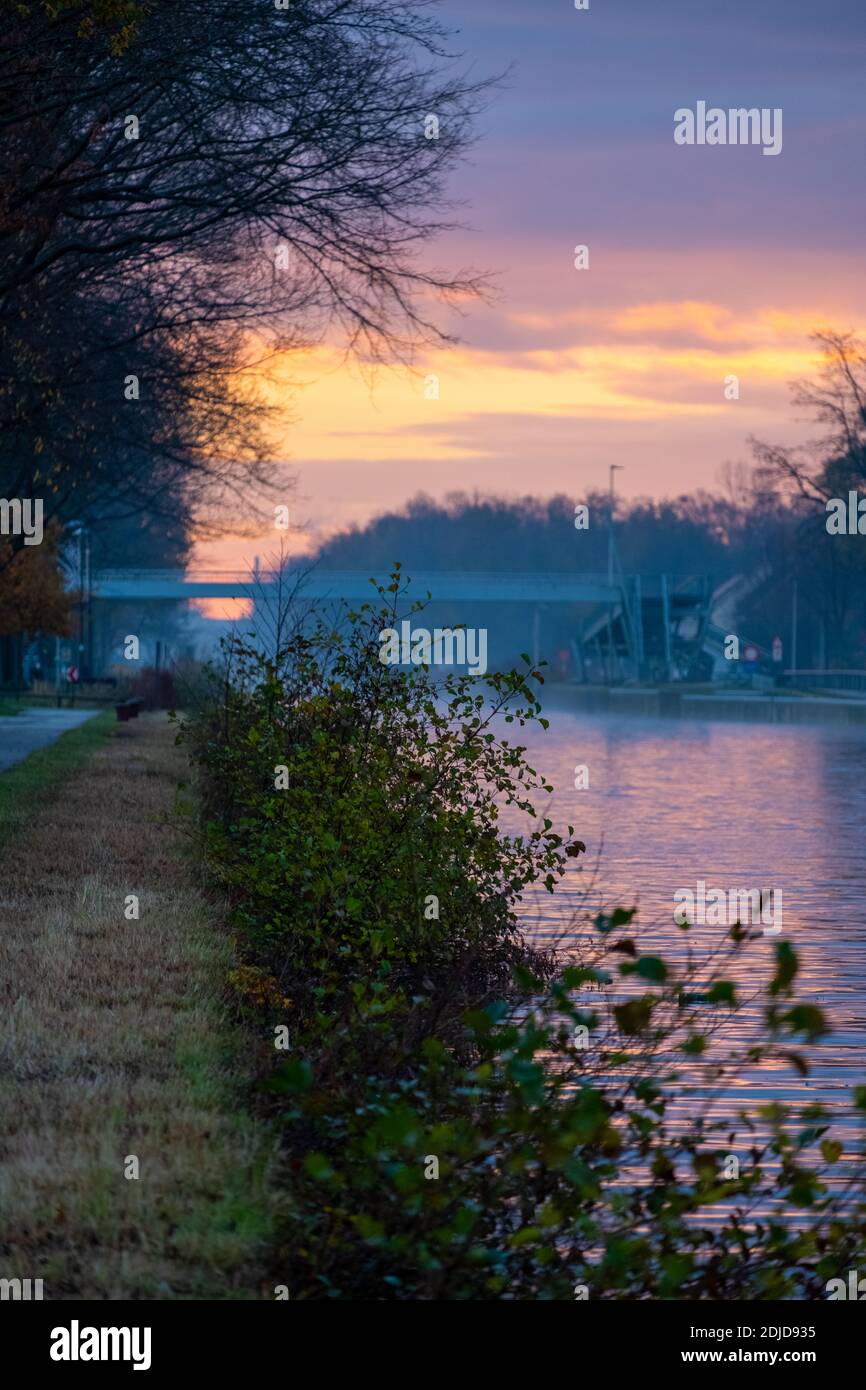 River stream canal bending with grass banks and wild flowers and trees ...
