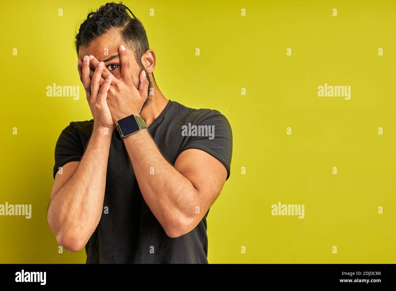 frightened man is scared of something, guy closed face with hands, look ...