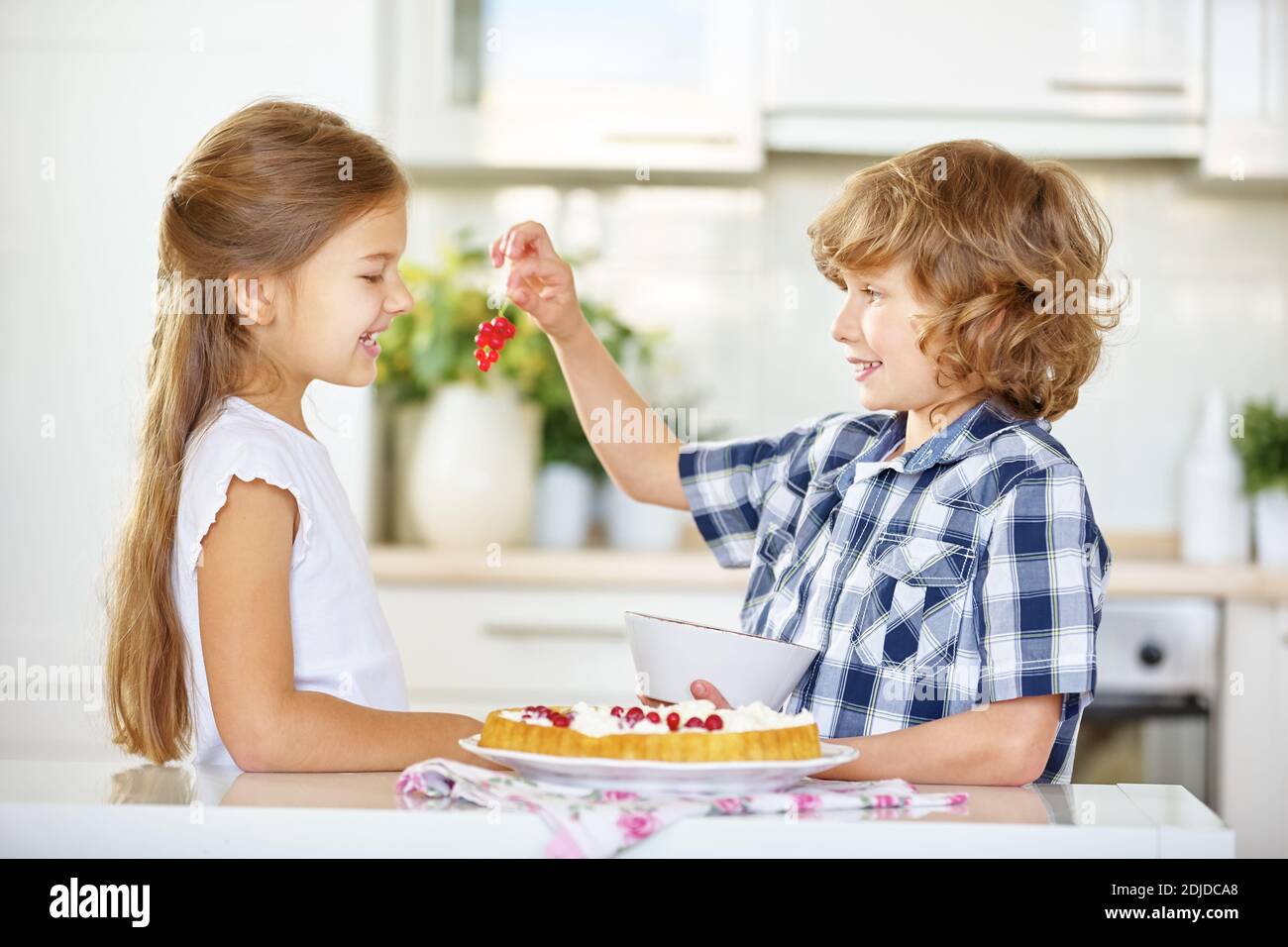 Side View Of Siblings Preparing Cake At Home Stock Photo - Alamy