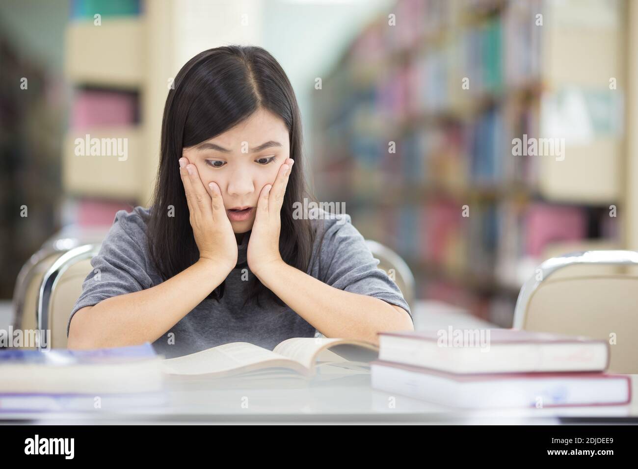 Woman shock reading book library hi-res stock photography and images ...
