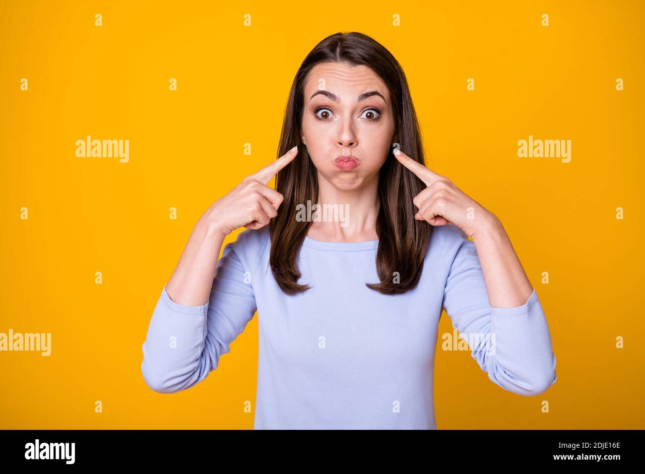 Photo of funny funky childish girl inflate cheeks point index finger ...