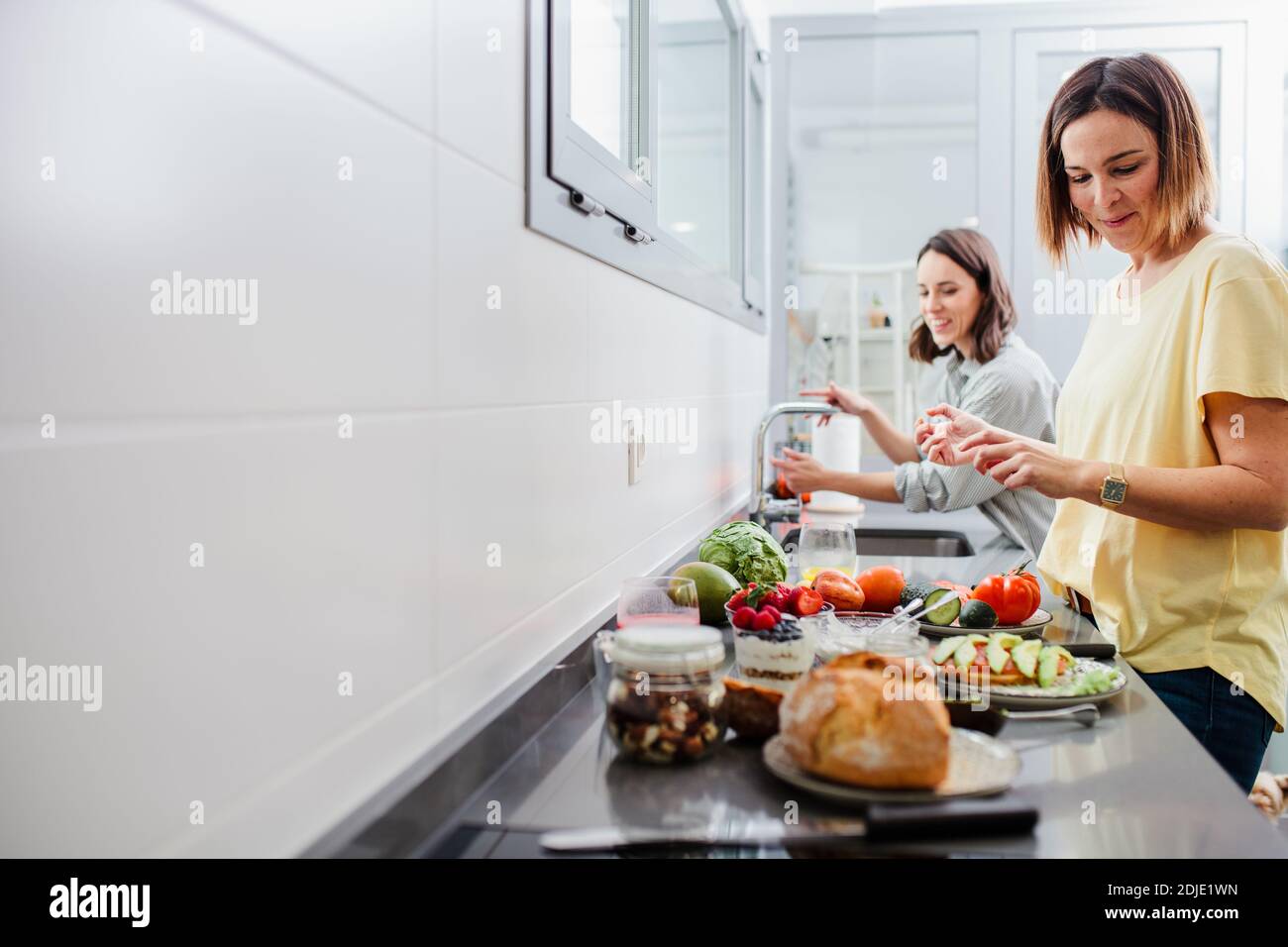 Two women preparing healthy food on the kitchen counter, diet and ...