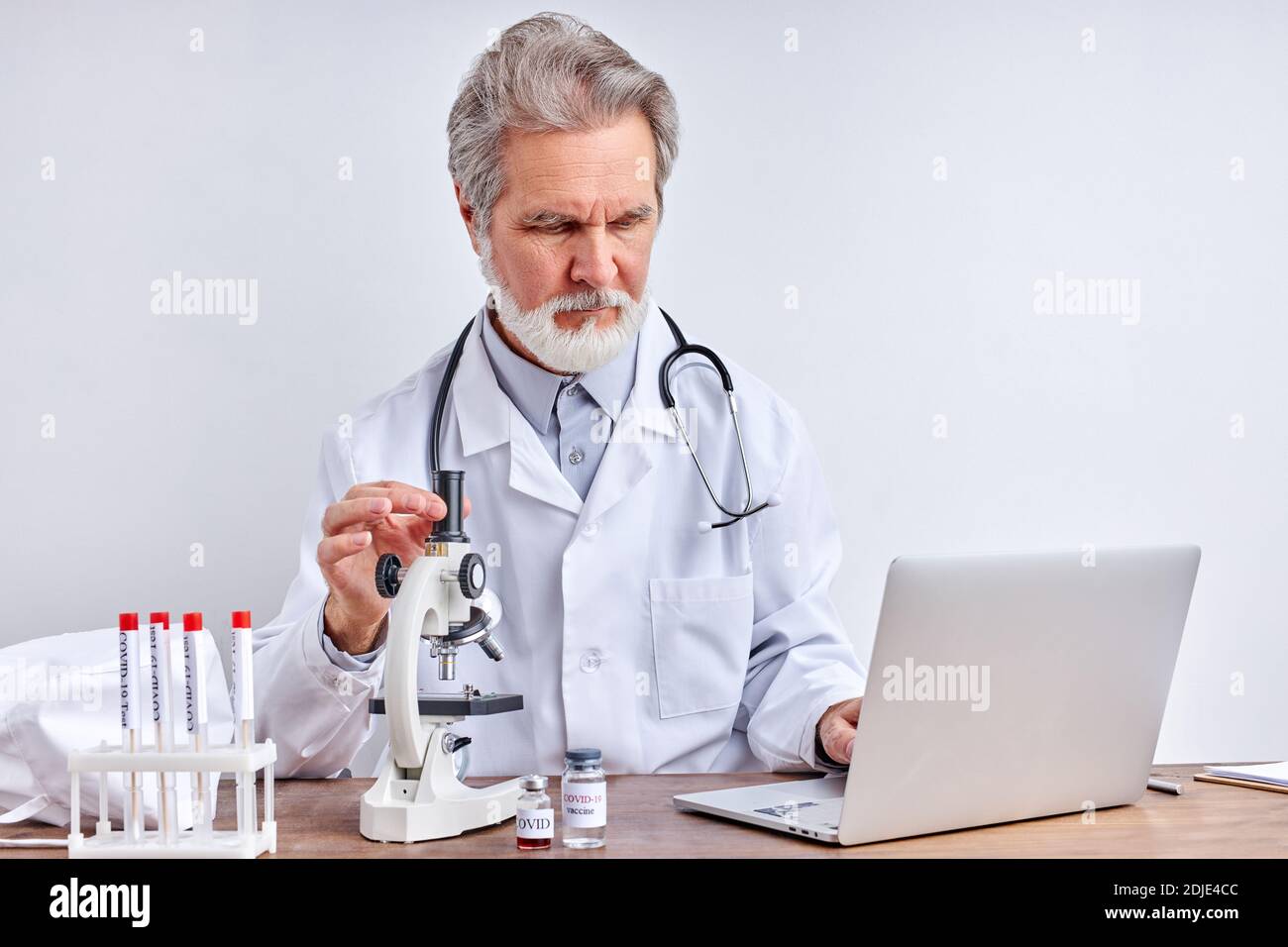 senior microbiologist with a tube of biological samples contaminated by ...