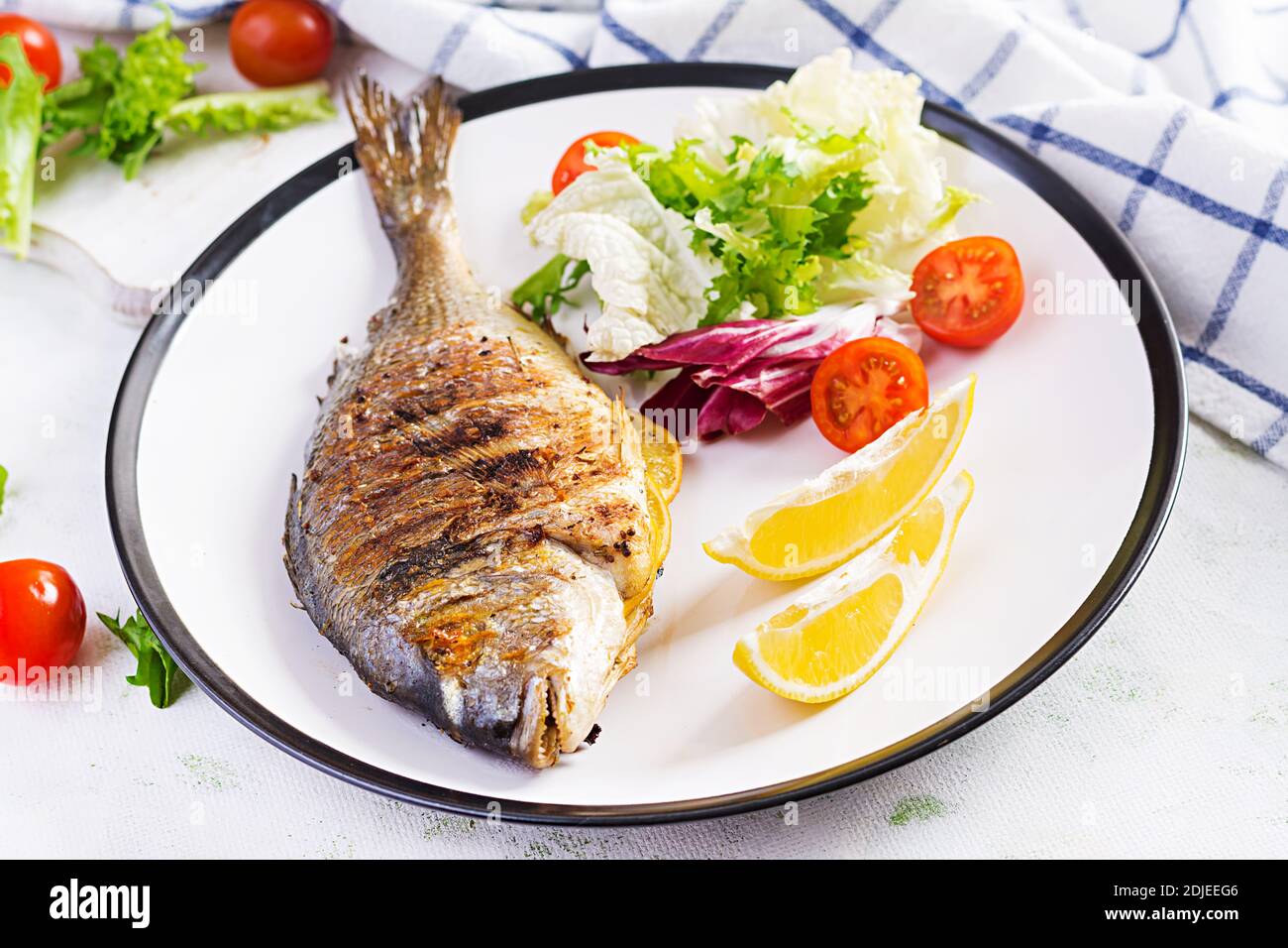 Delicious grilled dorado or sea bream fish with salad, spices, grilled ...