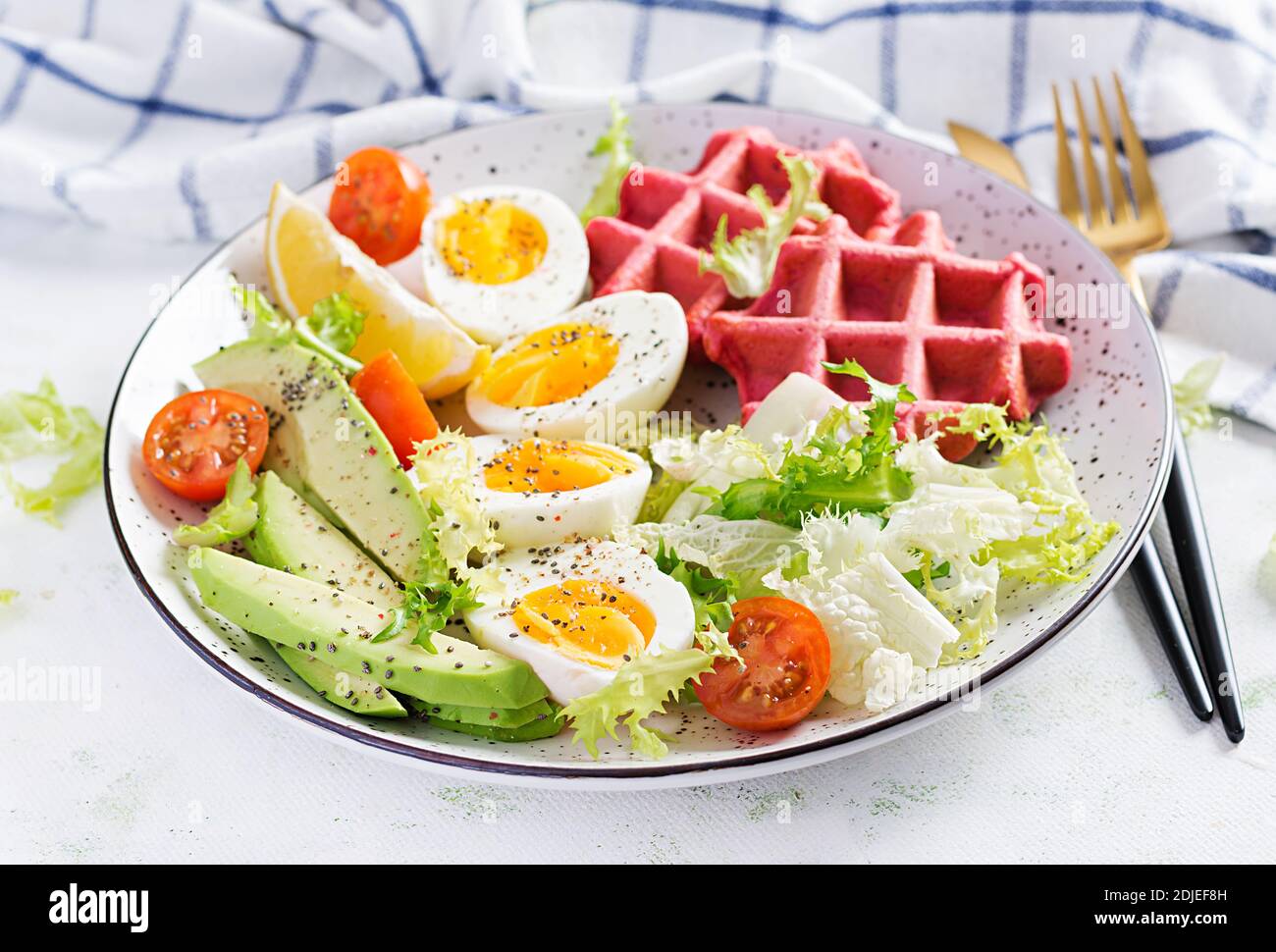 Breakfast with beetroot waffles, boiled egg, tomato and slice avocado ...