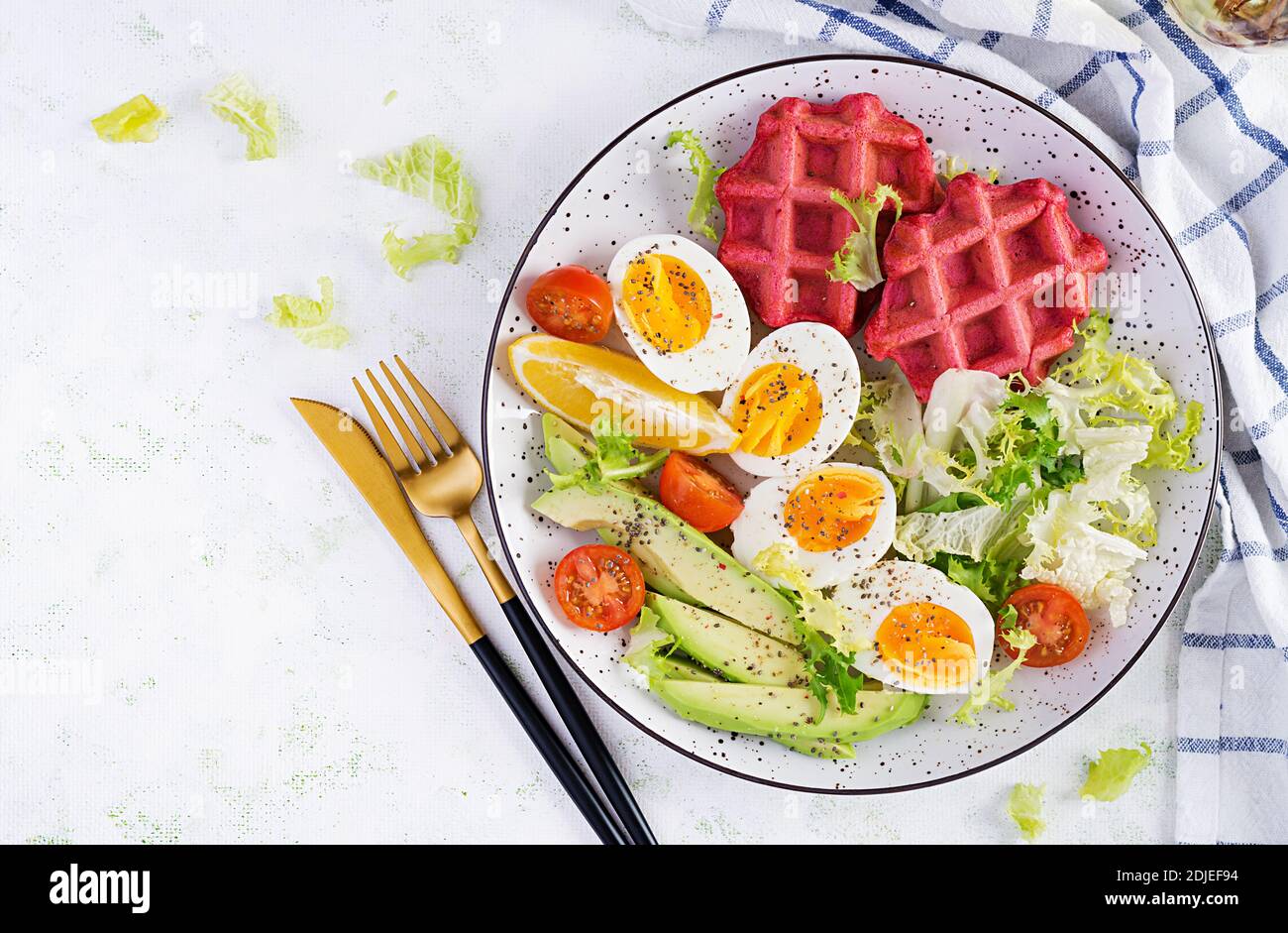 Breakfast with beetroot waffles, boiled egg, tomato and slice avocado ...