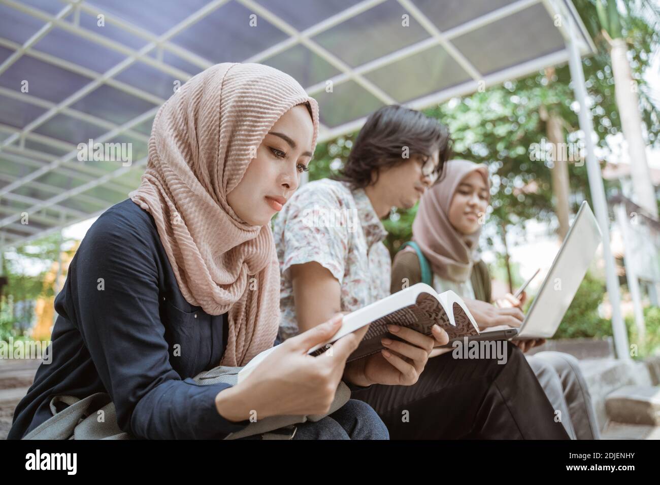 Portrait Muslim female student reading a book. With his friends in the ...
