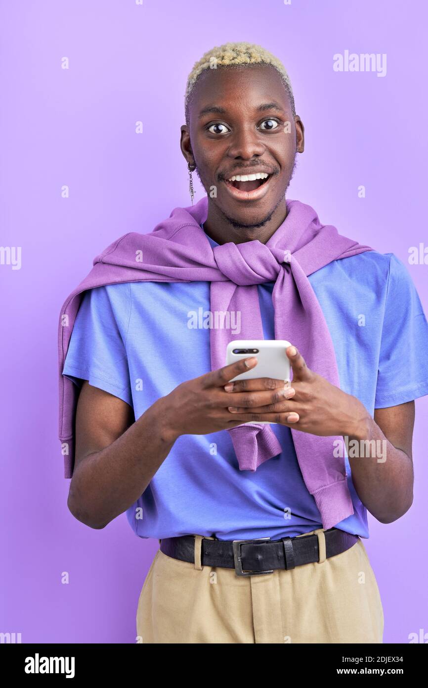 black man is in shock by news, while chatting with friend on smartphone ...