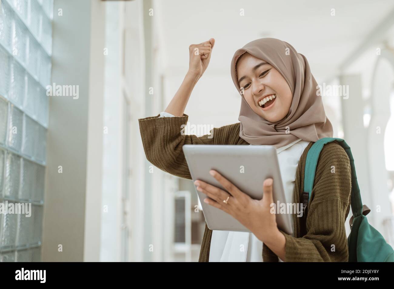 Portrait happy Muslim female student holding a tablet on campus Stock ...