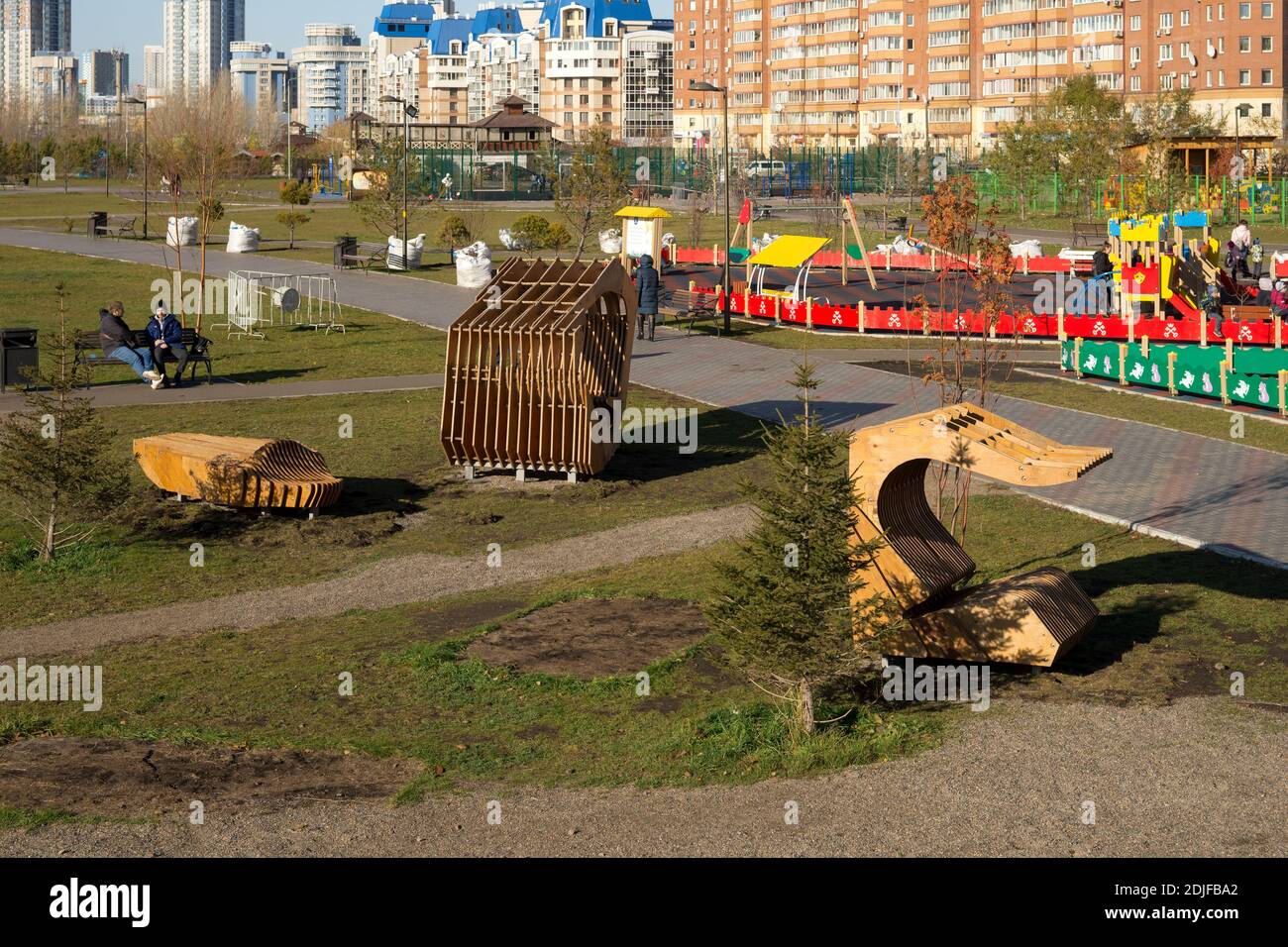 Wooden benches of the original form stand in the city square against ...