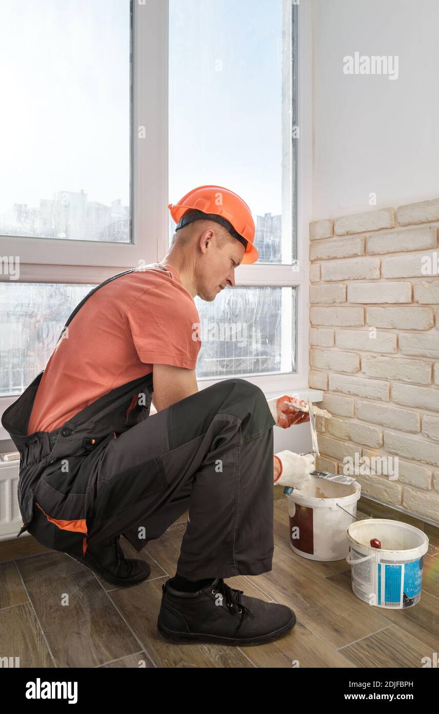 The worker is installing gypsum brick tiles on the wall Stock Photo - Alamy