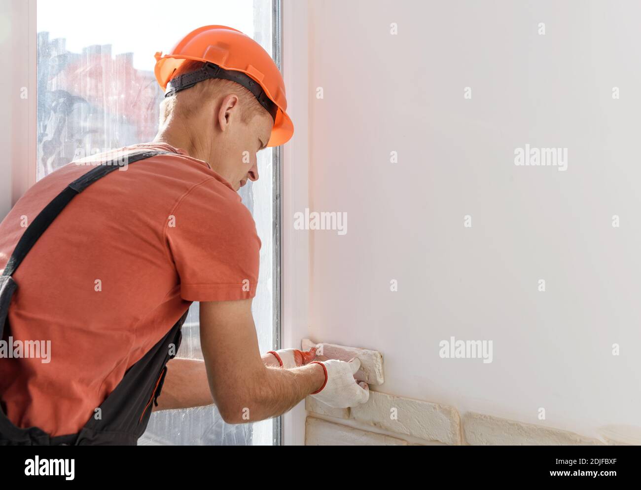 The worker is installing gypsum brick tiles on the wall Stock Photo - Alamy