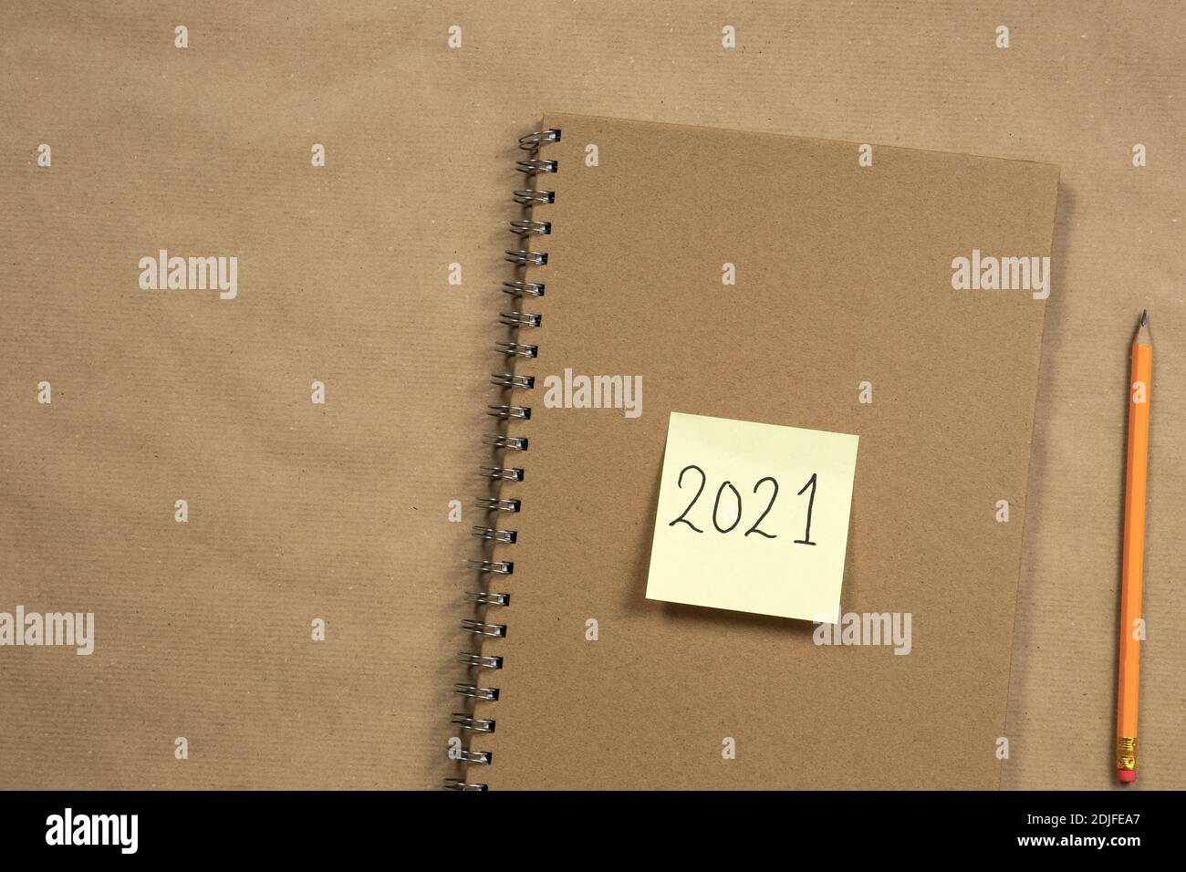Top view of Brown notepad and yellow sticky note with 2021 New Year's ...