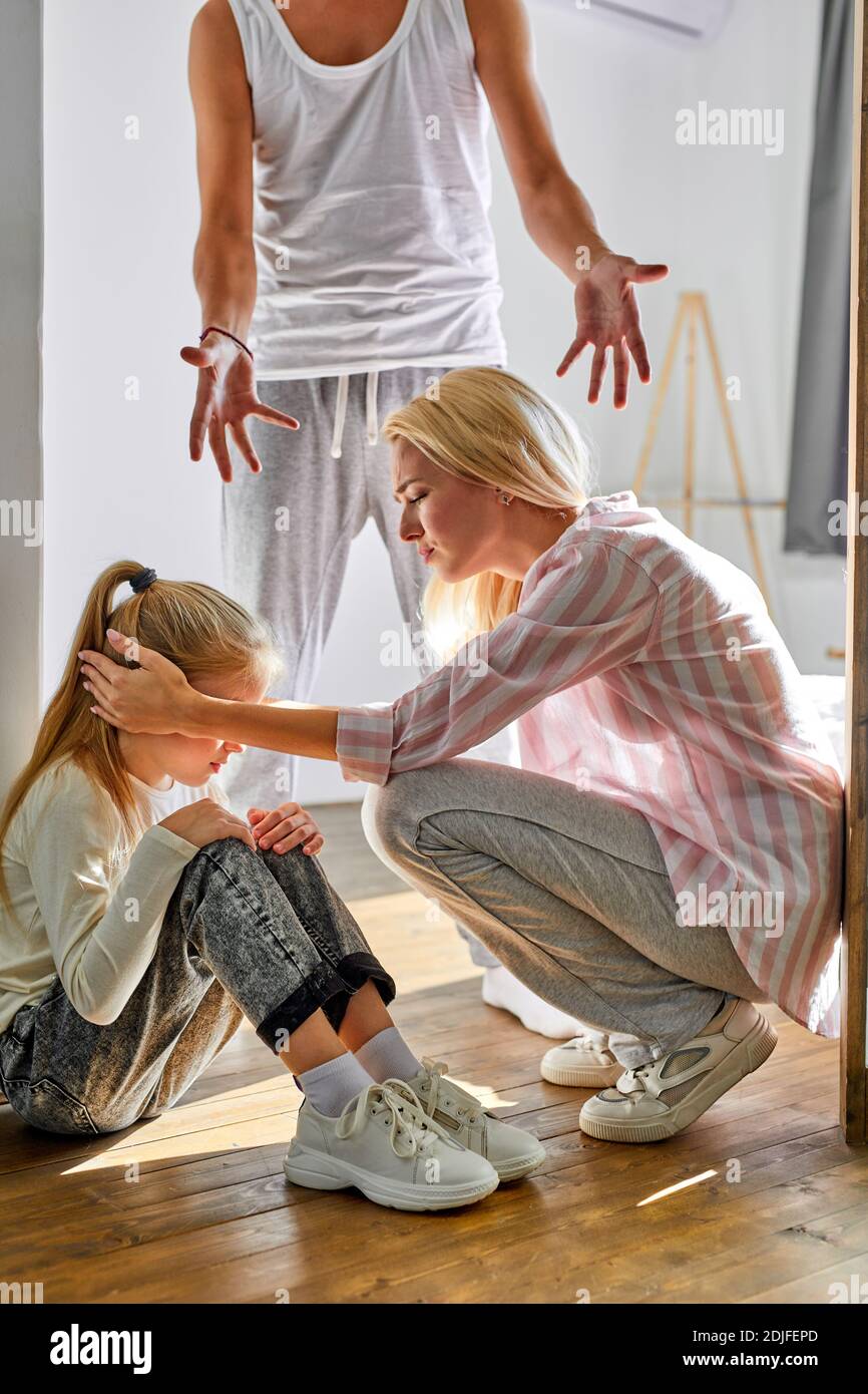 angry father scolds daughter and wife, family problems. scared child ...