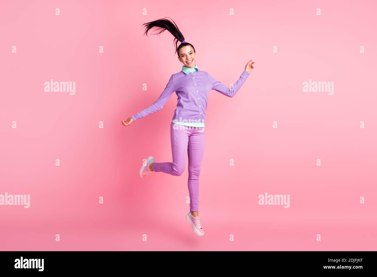 Full length photo of cute girl jump wind blow hair wear violet pullover ...