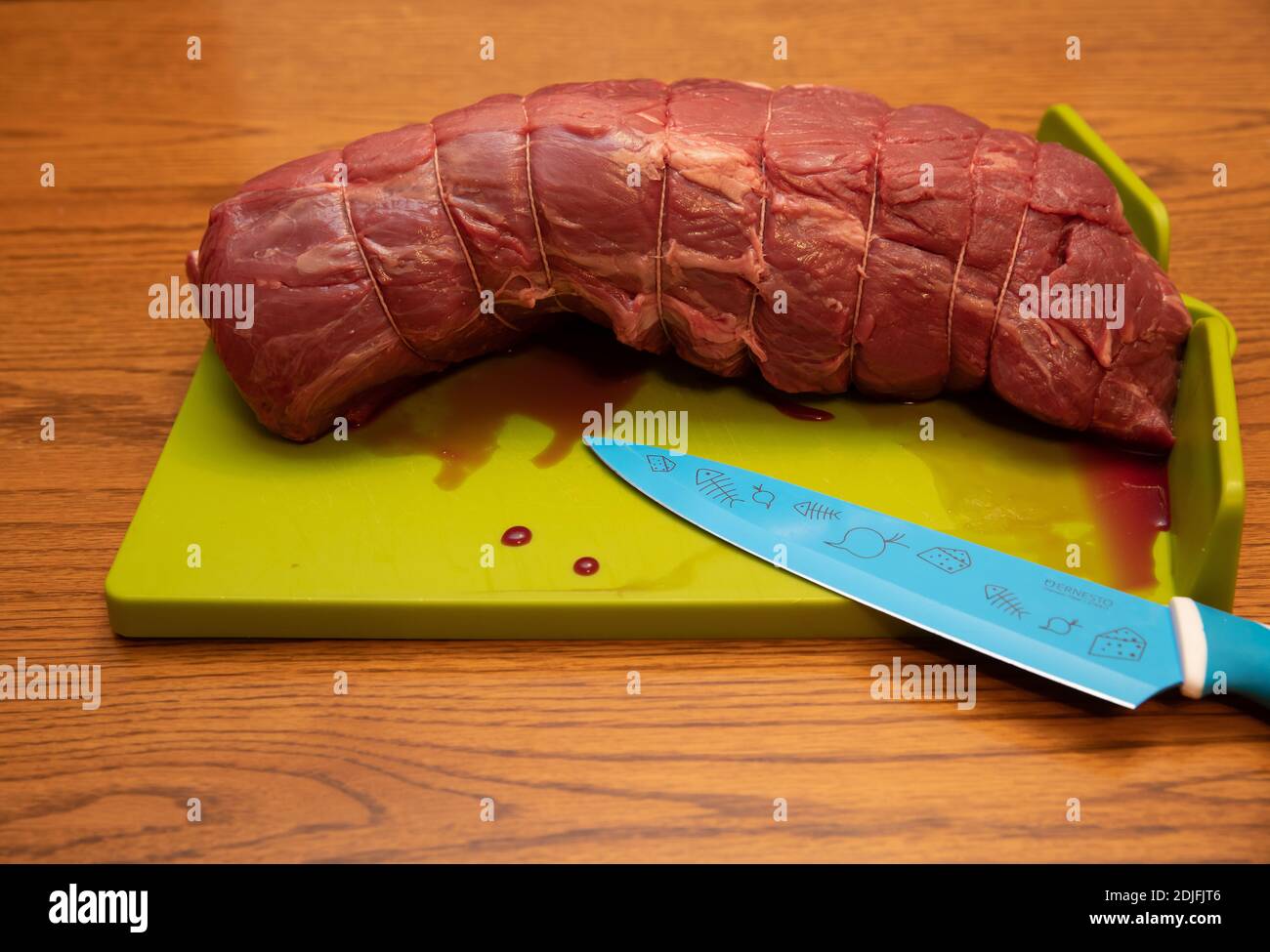 A large joint of Fresh Roasting Beef on a chopping board with a blue ...