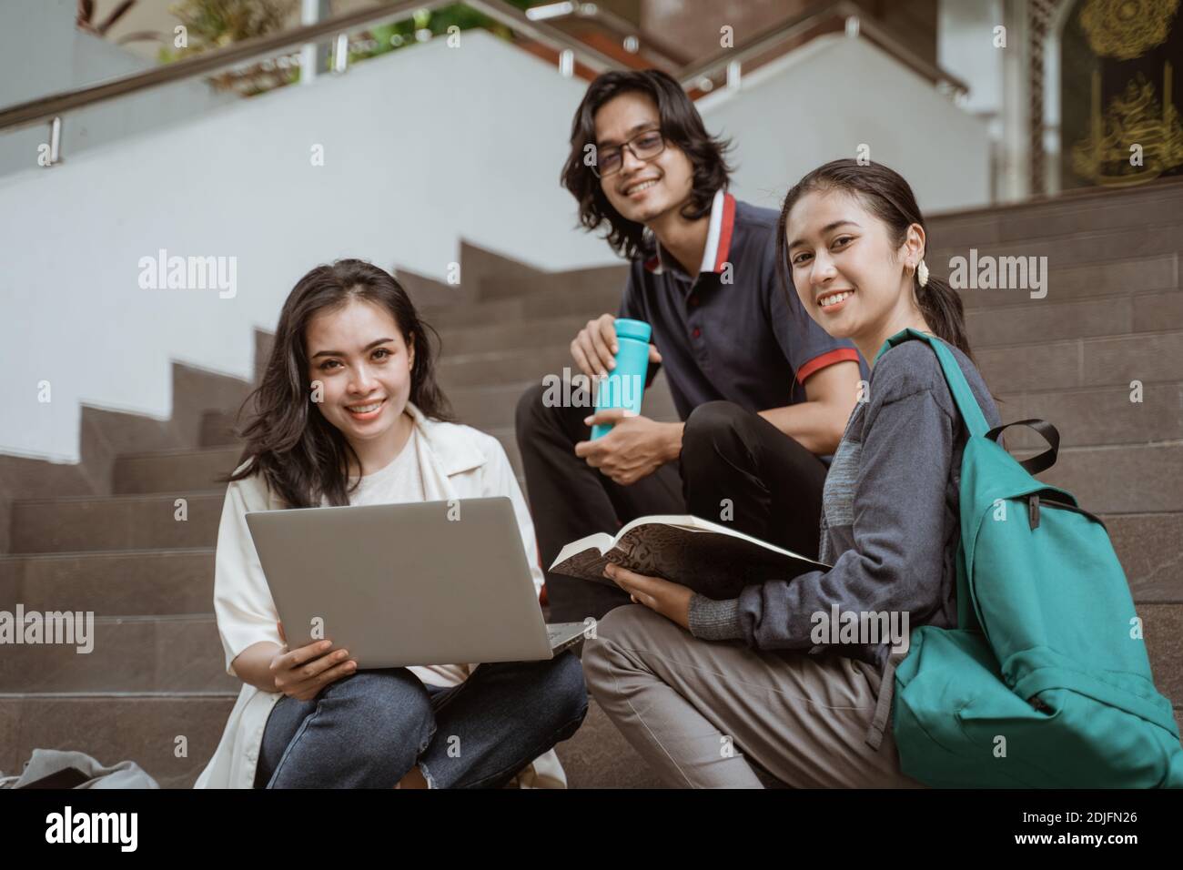 Portrait students sit down working in groups looking at camera on the ...