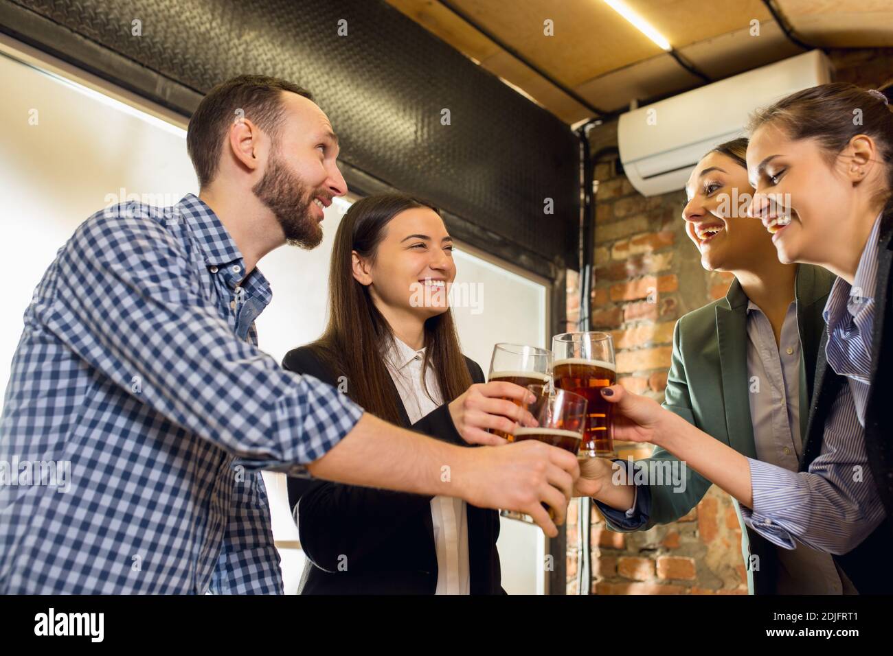 Clinking. Happy co-workers celebrating corporate event after tensioned ...