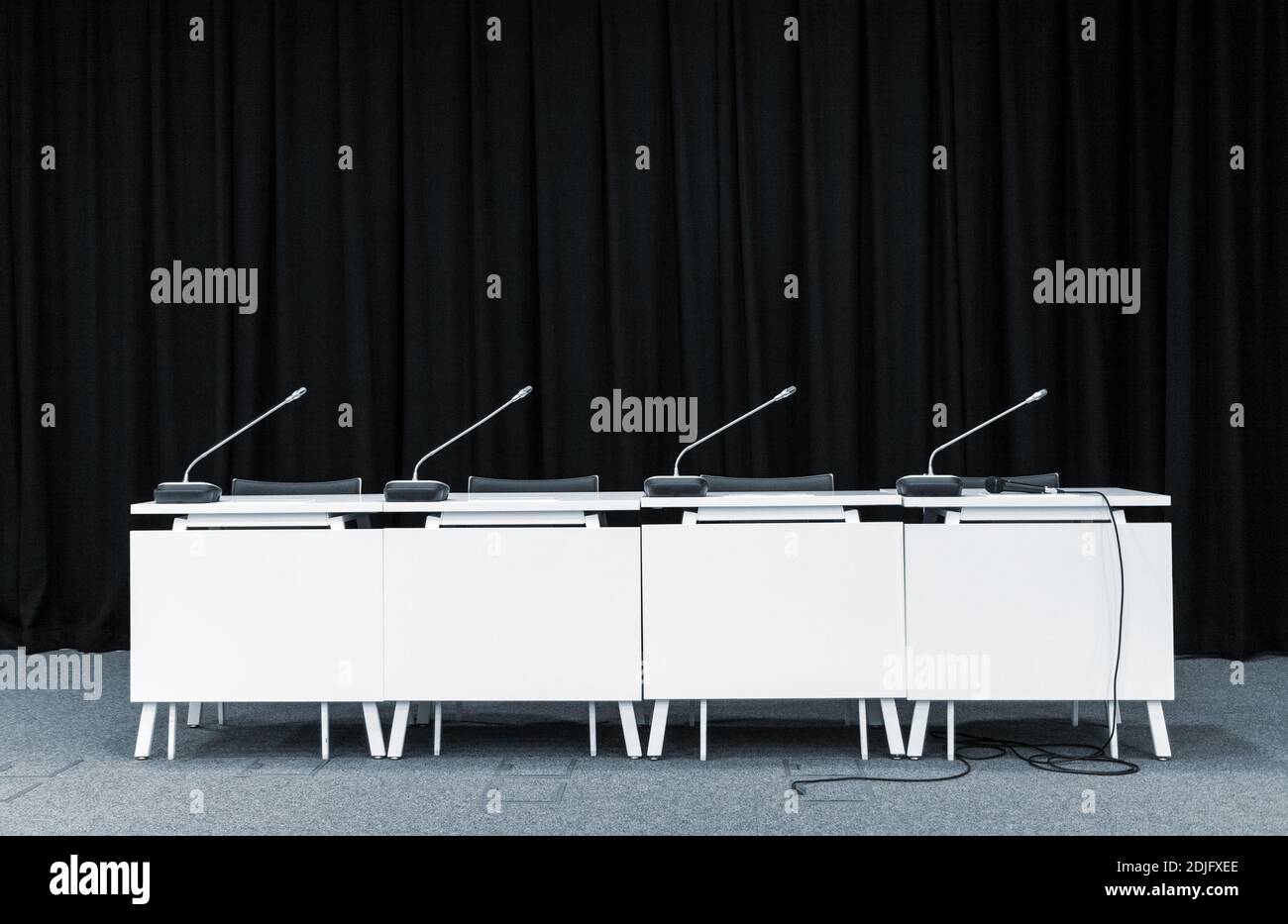 Monochrome picture of conference stand table with microphones in a ...
