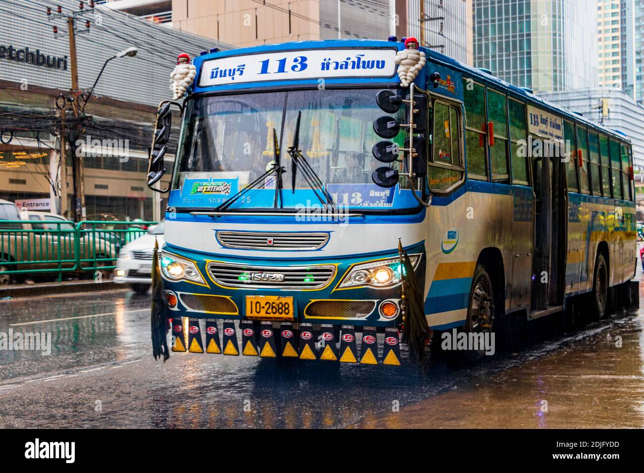 Typical colorful blue decorated bus in heavy rain in the metropolis of ...