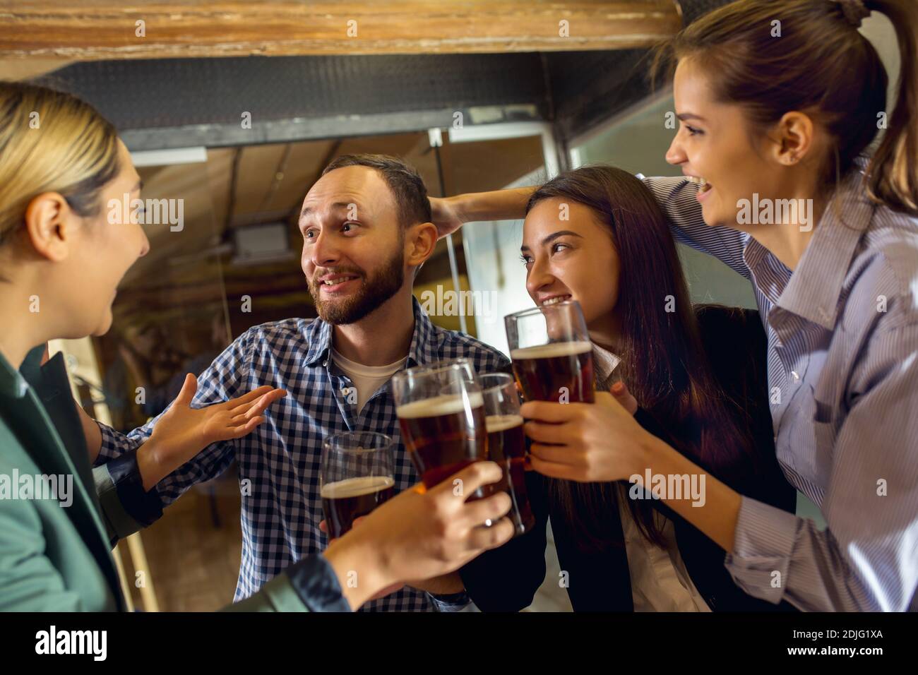 Clinking. Happy co-workers celebrating corporate event after tensioned ...