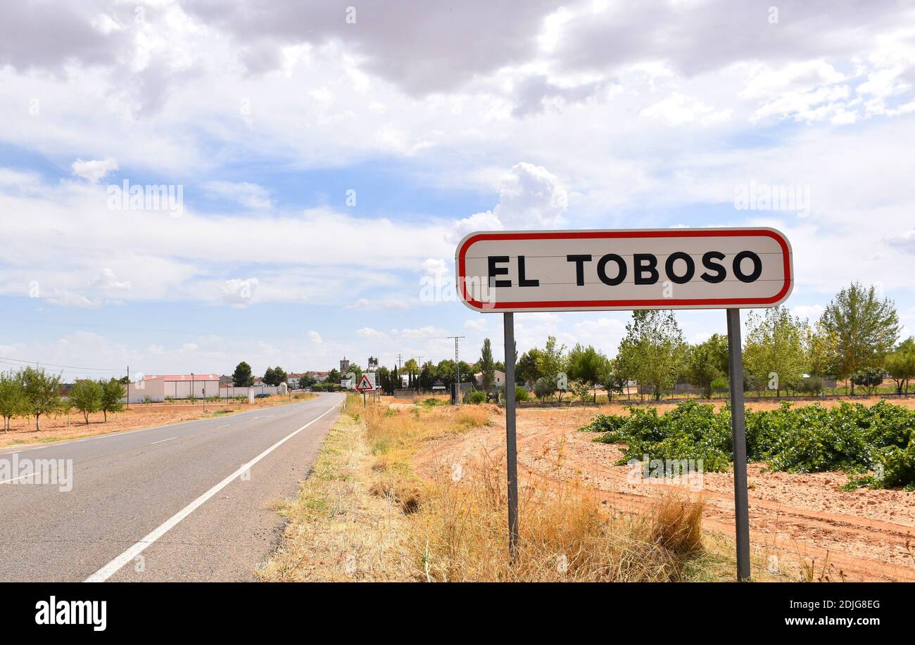 Entrance sign to El Toboso town. Vineyards on the right. Sunny and ...