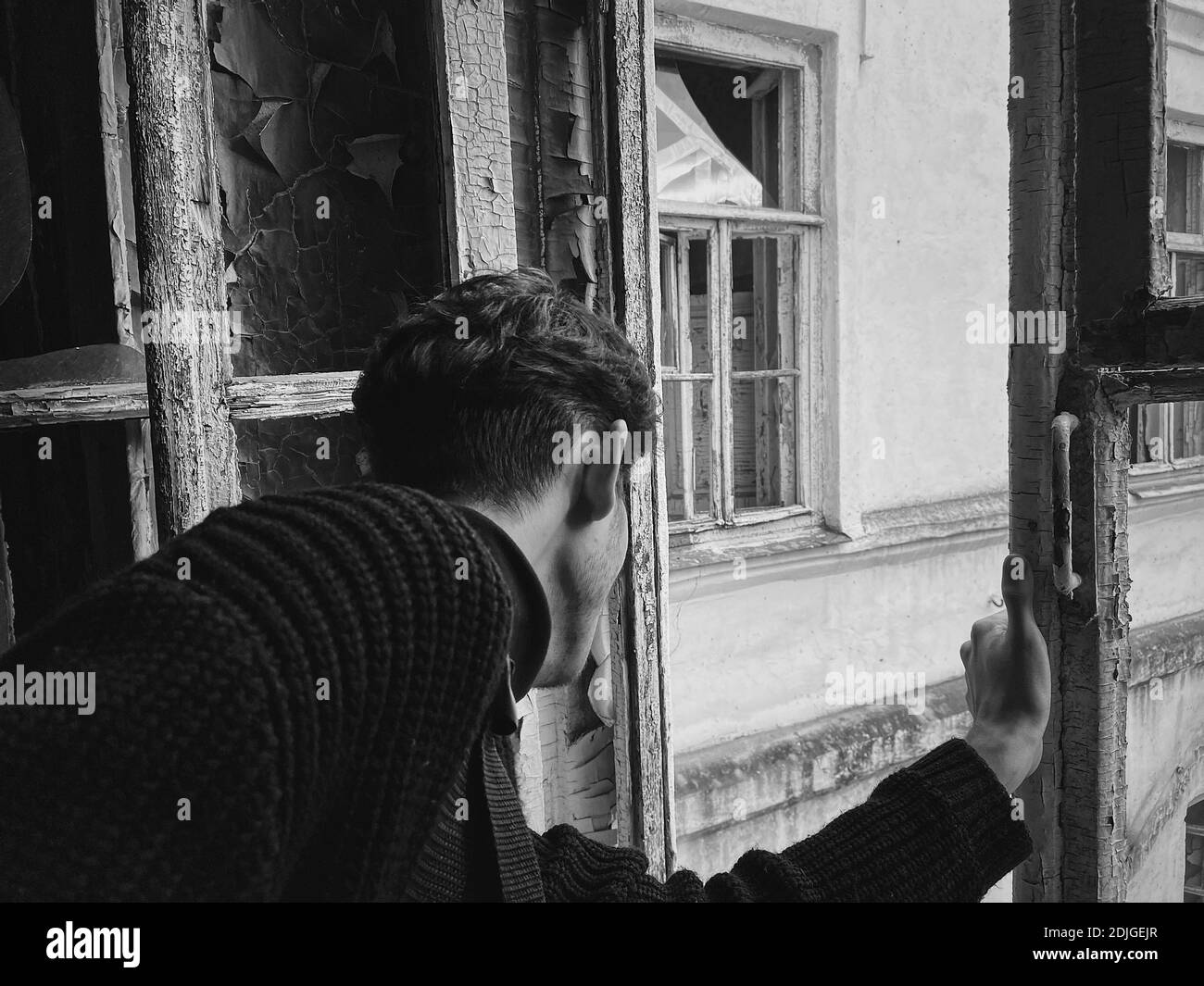 Young man standing window Black and White Stock Photos & Images - Alamy