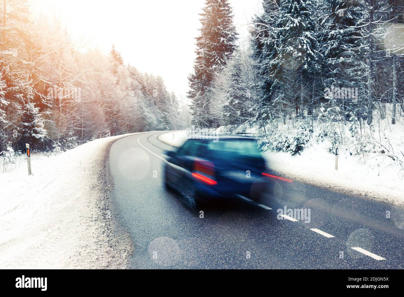 Lonely car in motion blur on the road in winter landscape with sunset ...
