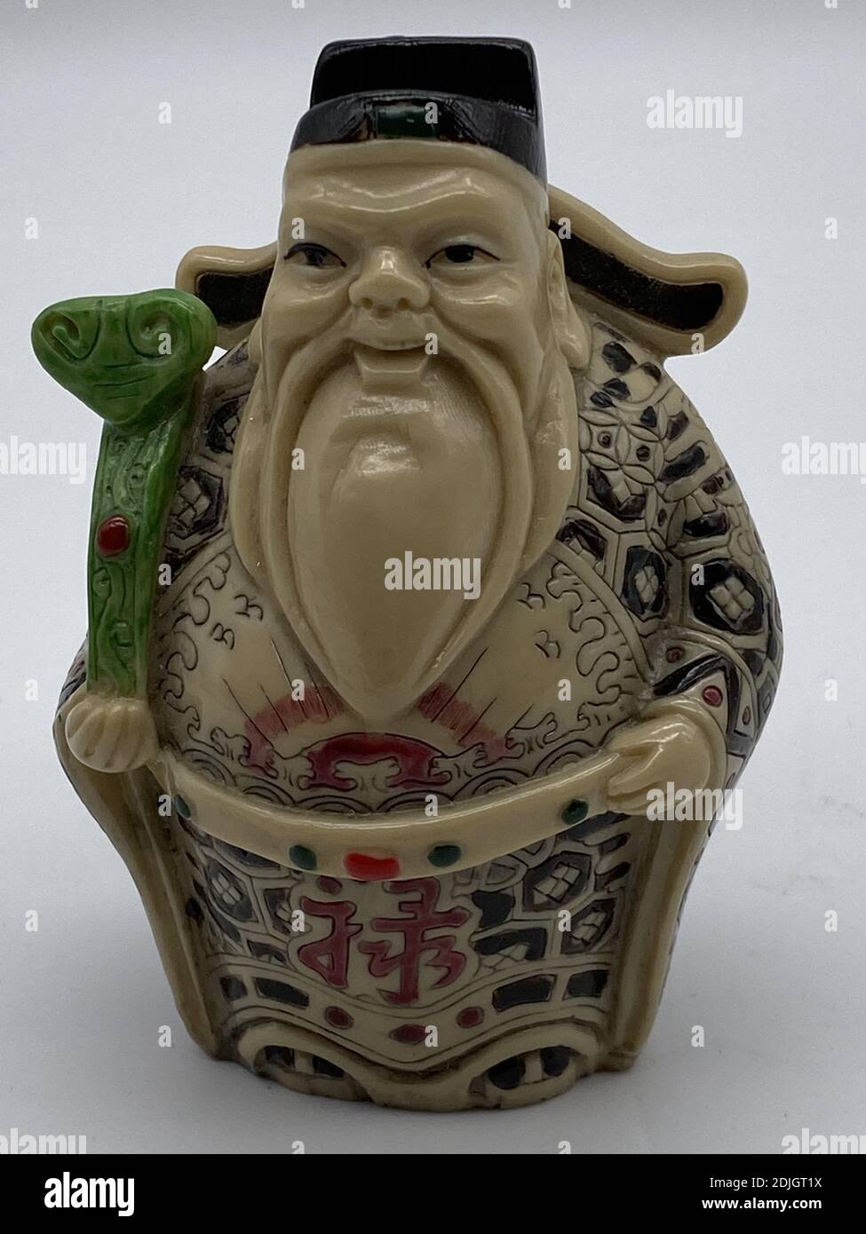 A vertical shot of a porcelain Chinese man figurine isolated on white ...