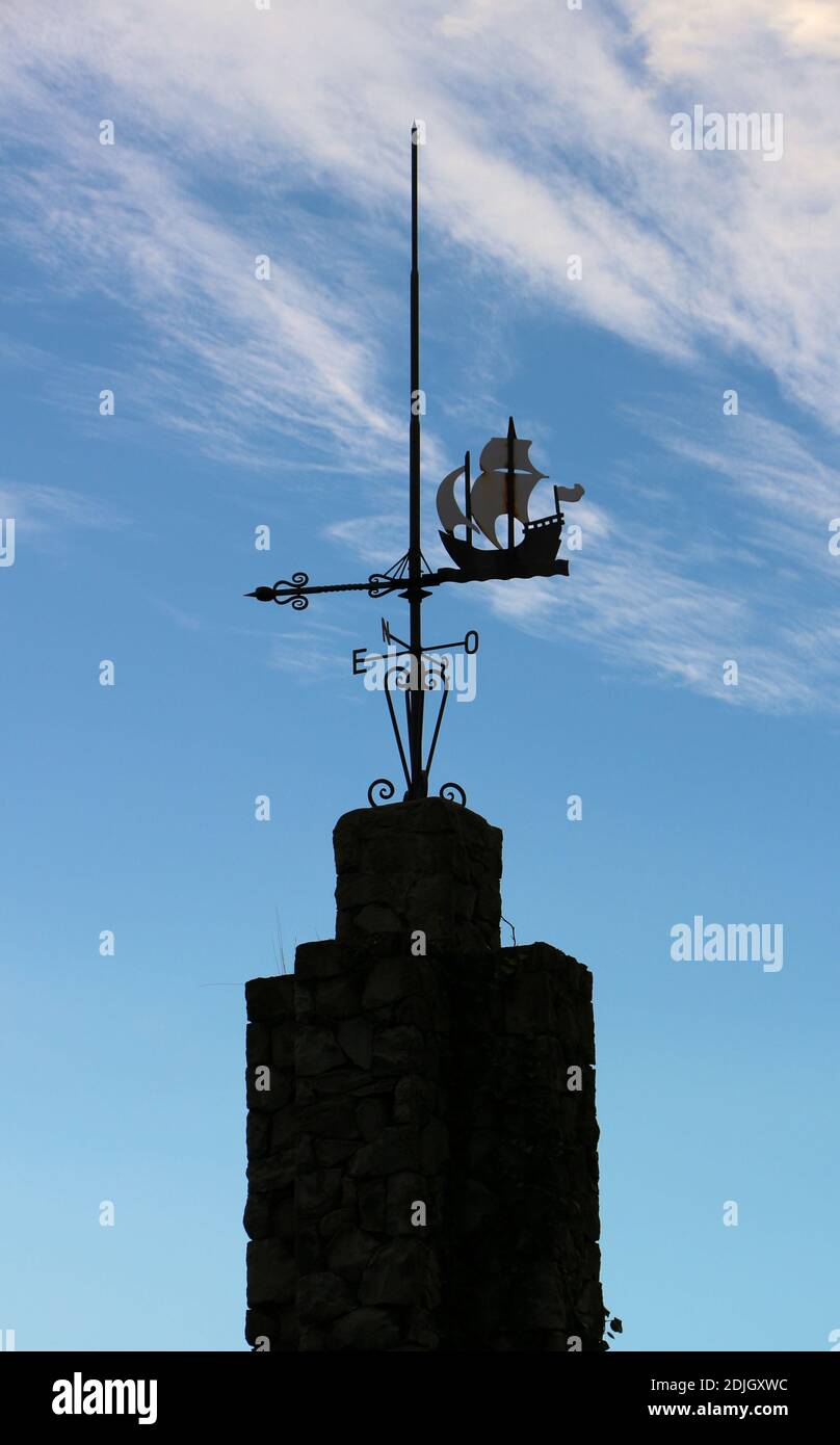 Tall weather vane with a galleon on top of a stone structure in the ...