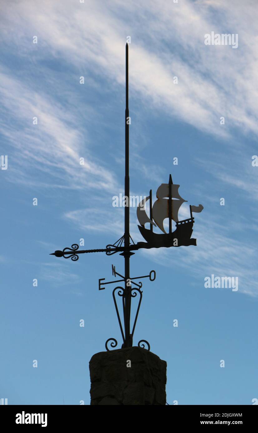Tall weather vane with a galleon on top of a stone structure in the ...