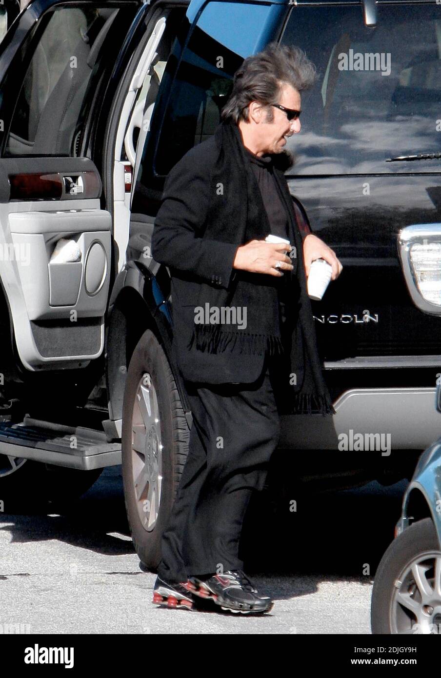 Al Pacino, wearing his trade mark black, takes two cups of coffe for a ...