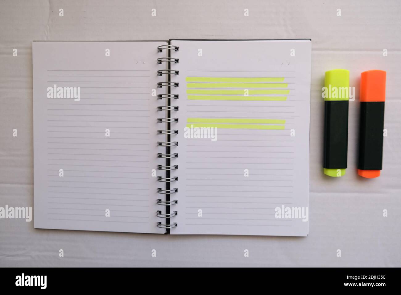 orange and yellow hihglighter on the empty lined notebook. preparation ...