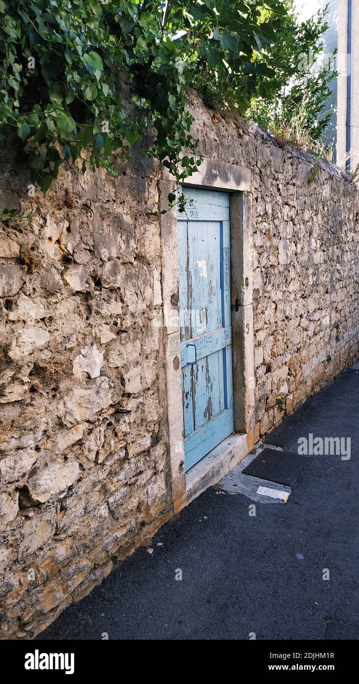 View on an old blue gate in a ancient stone wall Stock Photo - Alamy