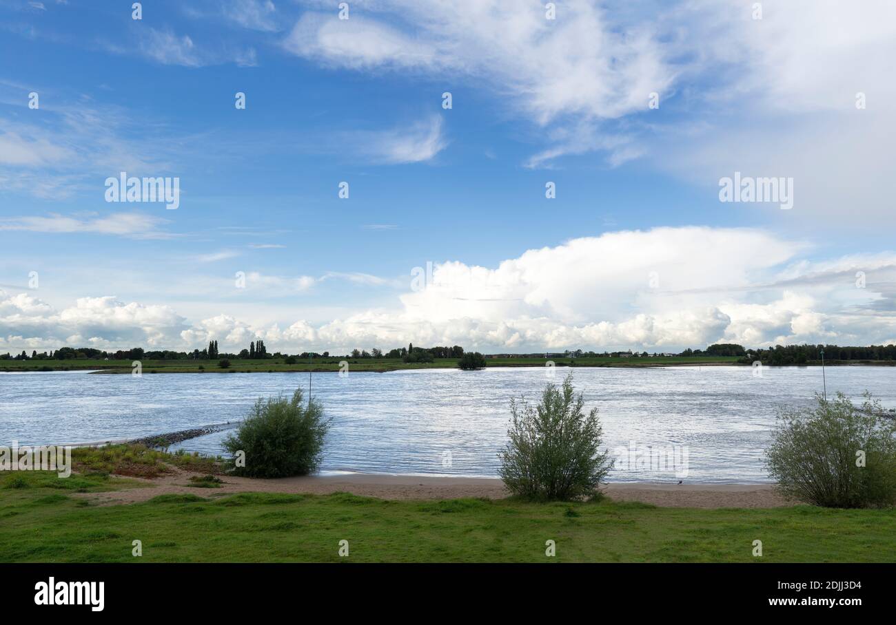 A Dutch river landscape River Lek with grassland riverbanks and blue ...